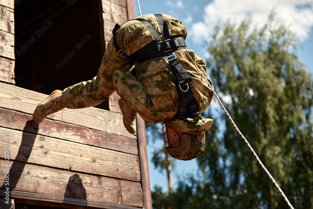 Special forces operator during assault rappeling with weapons. Soldiers ...