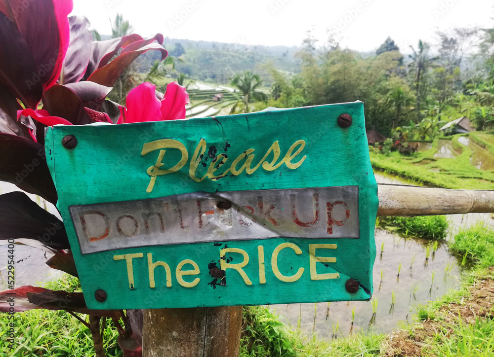 Foto de Green sign board with warning "Please Don't Pick Up the Rice ...