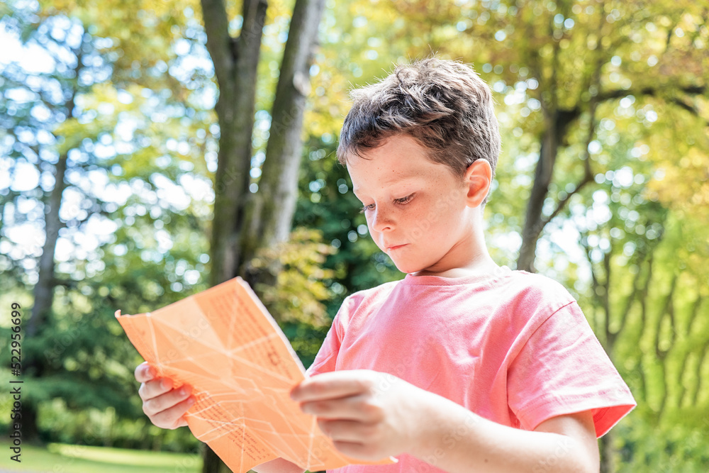 Boy reading map in park Stock Photo | Adobe Stock