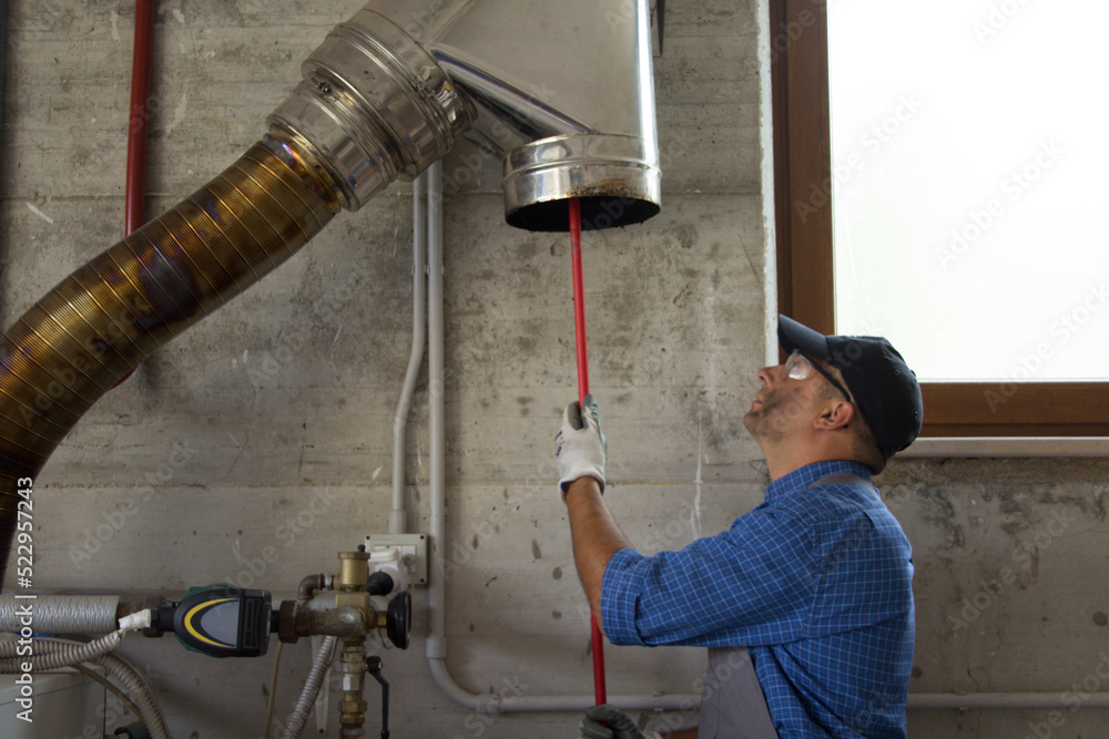Foto de Picture of a handyman cleaning the stainless steel pipe of a ...