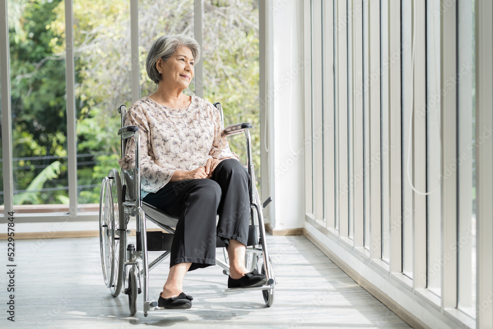 Elderly adult retired asian woman sit on wheelchair at home. Smiling ...