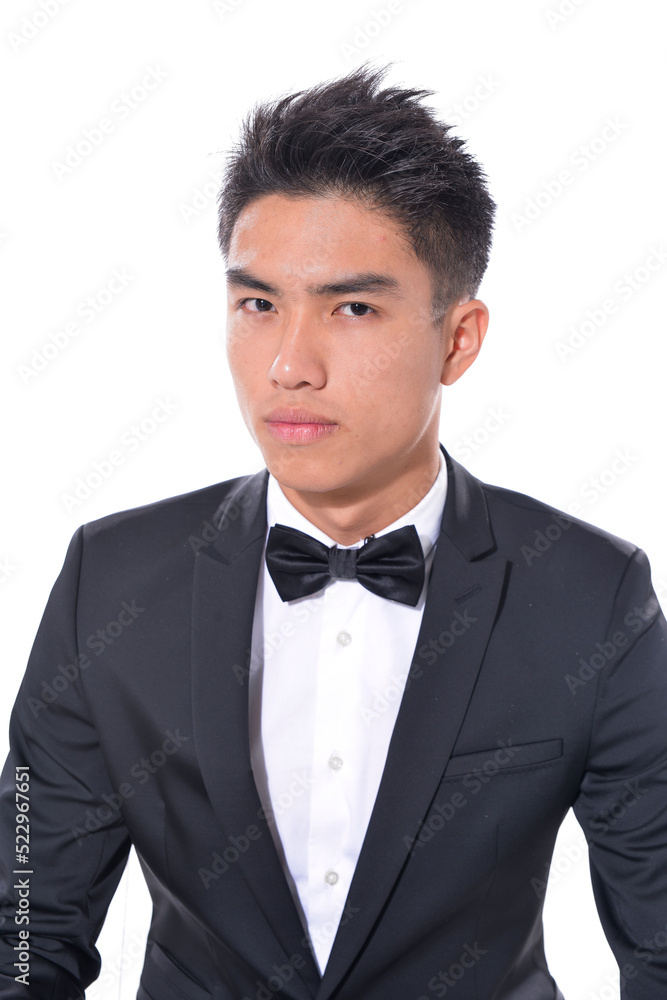 Handsome fashion model. elegant man wear formal black suit with bow tie ...