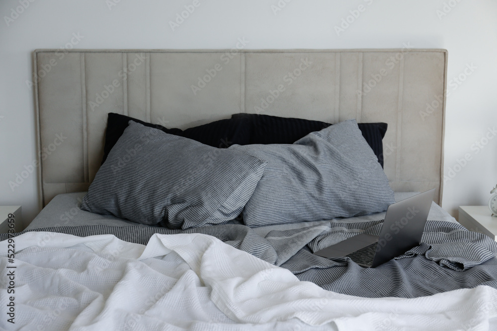 Laptop on a king sized bed with headboard, perfectly clean and ironed ...