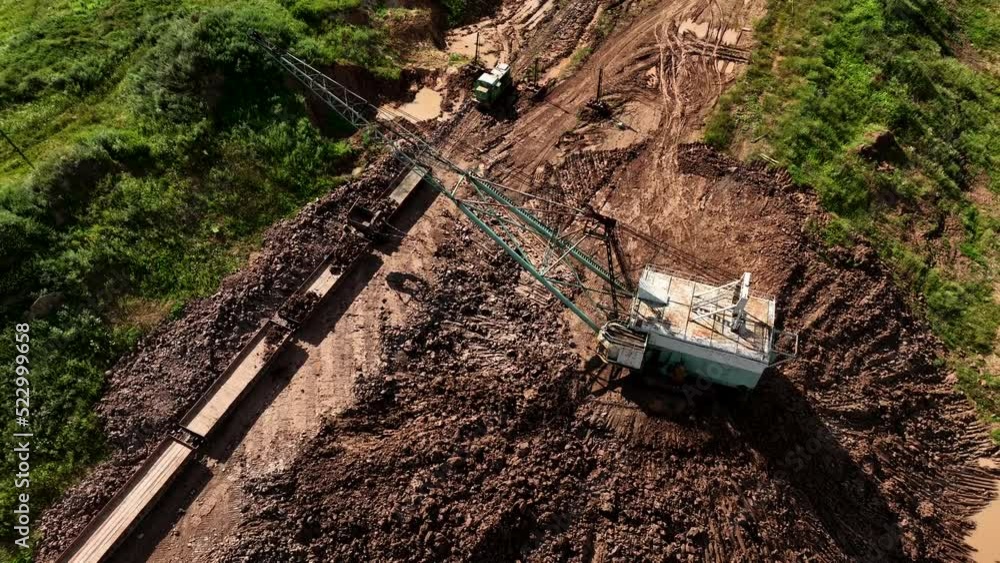 Open-pit mining. Dragline excavator load clay in freight train. Clay ...
