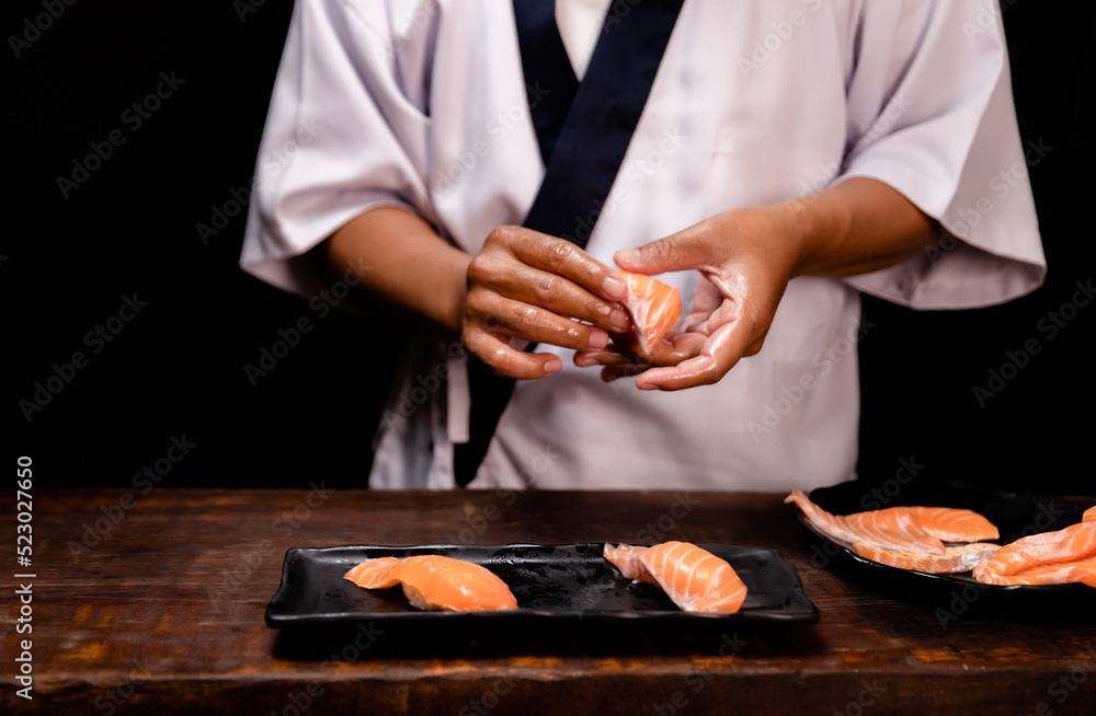 Chef's hand holding fresh piece of salmon.Closeup of chef hands ...