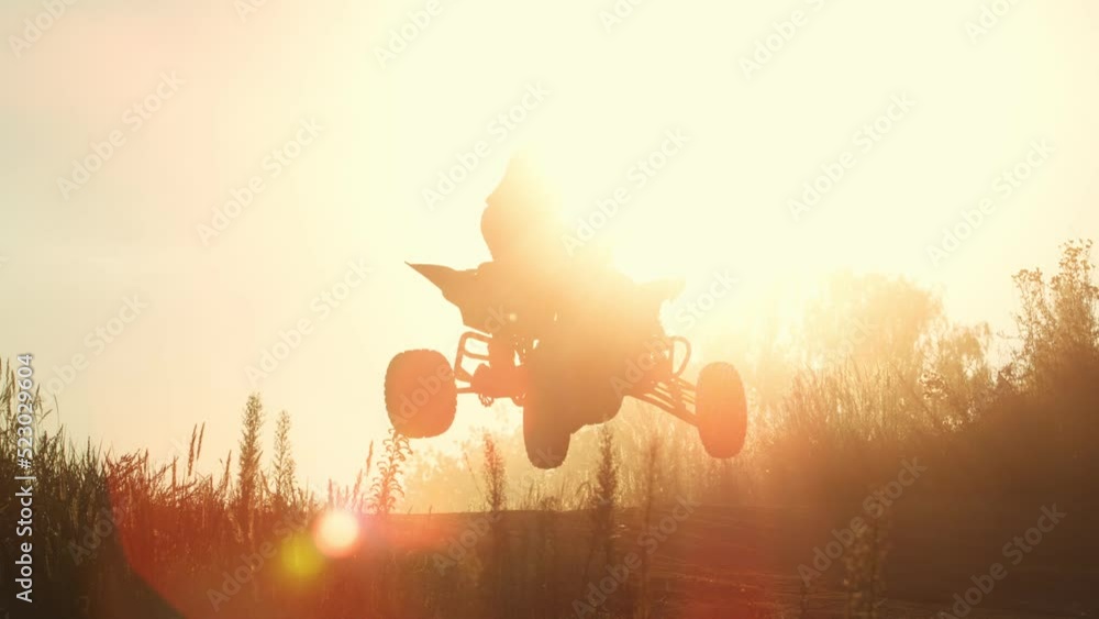 Super Slow Motion of Jumping Quad Biker in Sunset. Filmed on High Speed ...