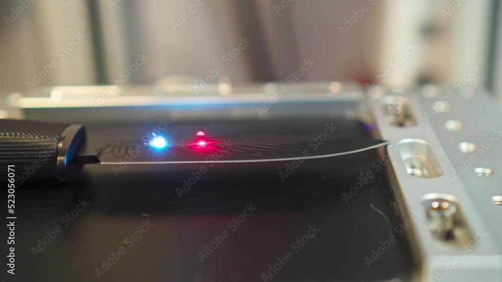 Camera horizontally passing by hunting knife in laser engraving process ...