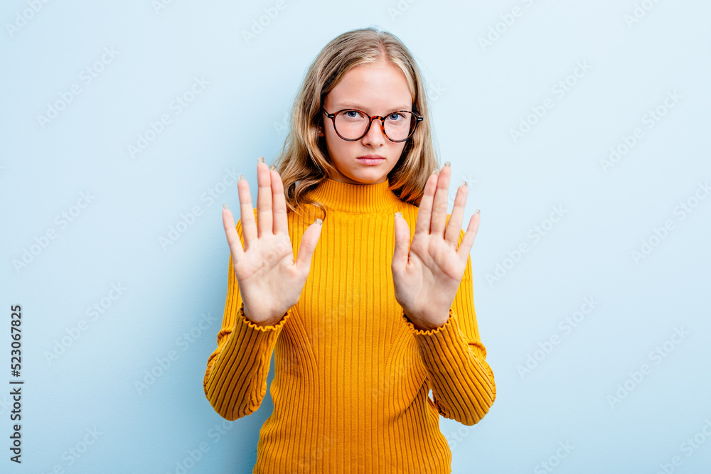 Caucasian teen girl isolated on blue background standing with ...