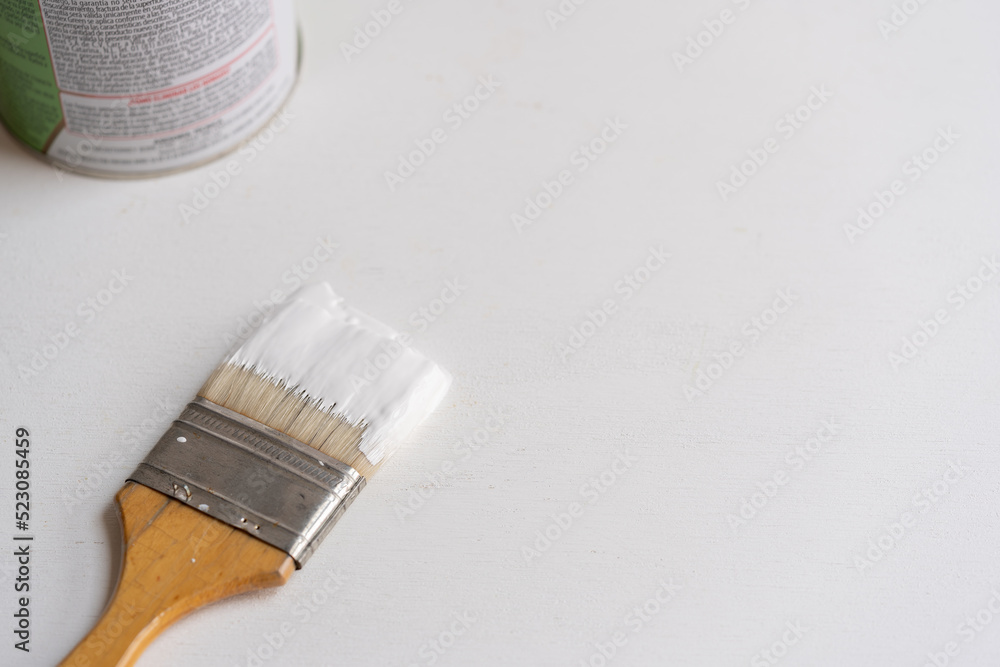 detalle de brocha con pintura blanca fresca sobre madera recién pintada ...