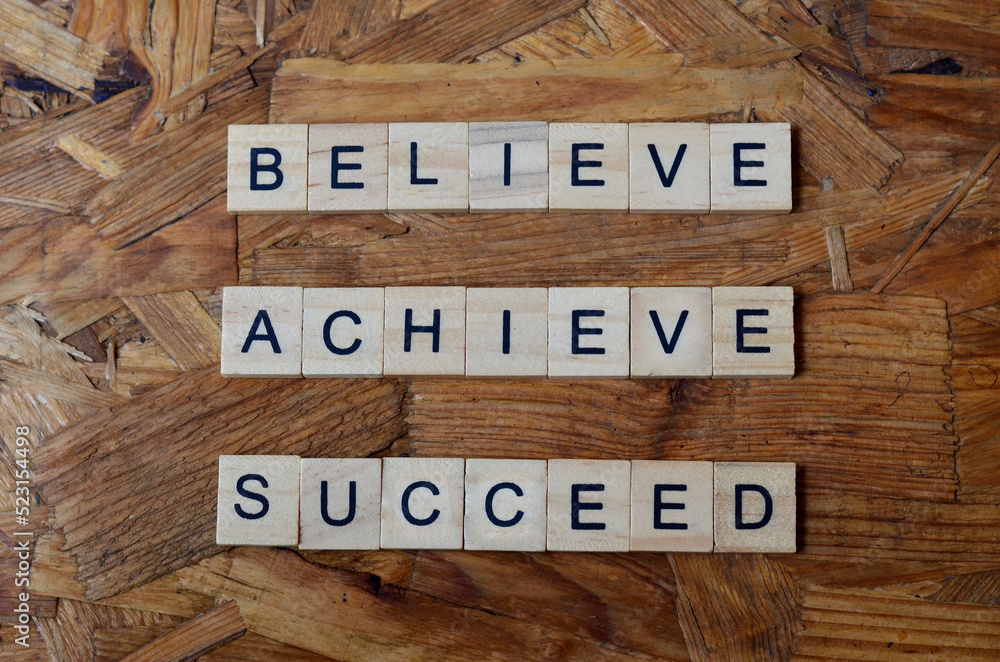 believe achieve succeed text on wooden square, inspiration and ...