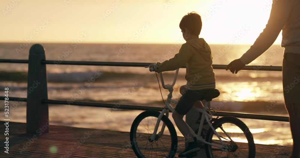 Learning to ride a bike with a father teaching his son to cycle at the ...