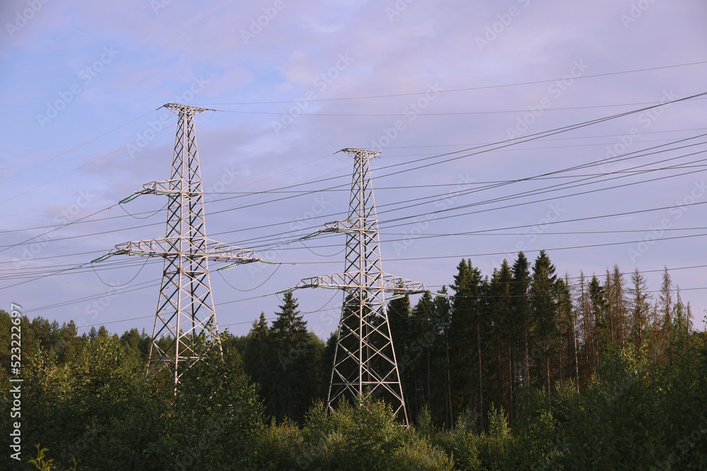 silhouette of high voltage power lines against a colorful sky ...