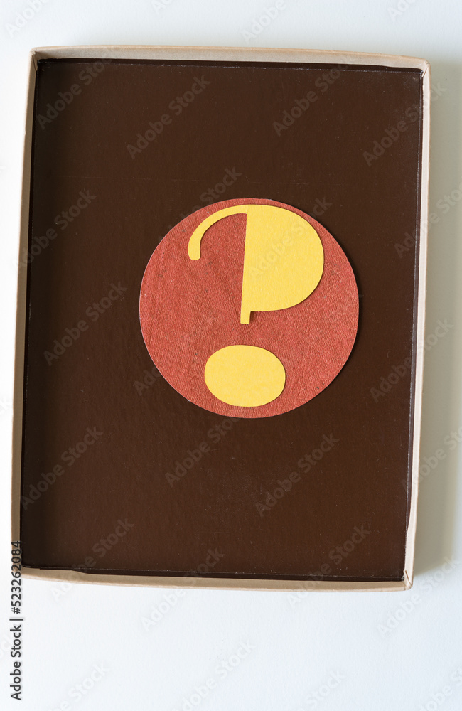 question mark on a circle inside a plain cardboard box with dark brown ...