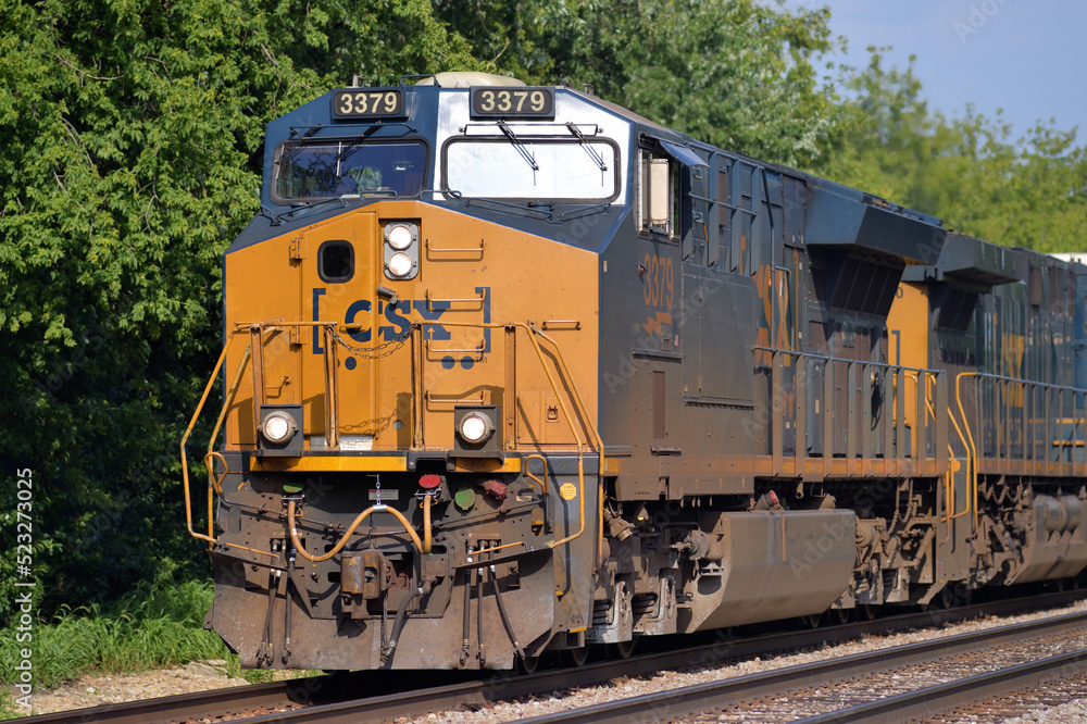Two locomotives lead a freight train through suburban Chicago. The ...