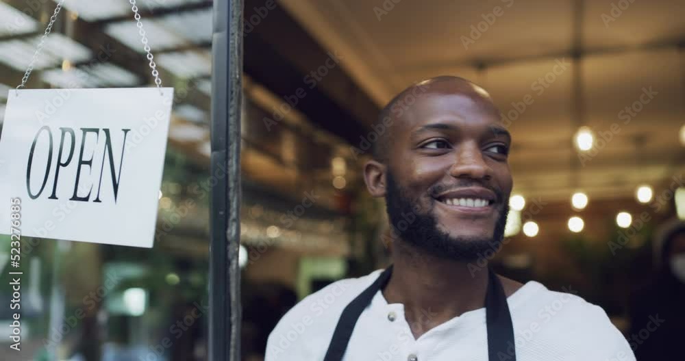 Cafe owner turning open door sign at entrance to show, greet and ...