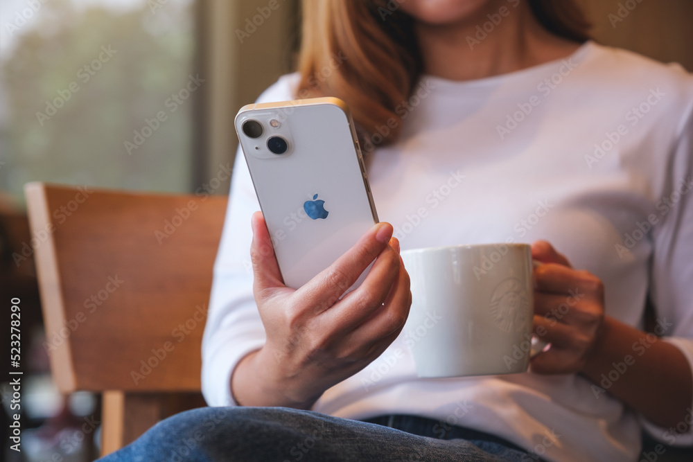 Aug 11th 2022 : A woman holding and using Iphone 13 smart phone while ...