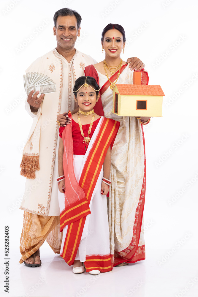 Happy bengali family holding model house and 500 hundred notes in hands ...