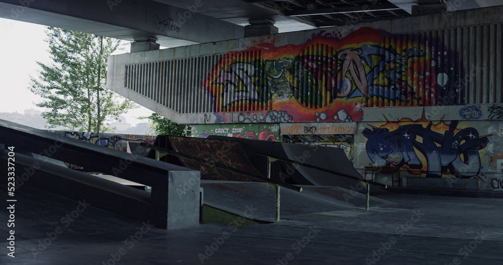 Nobody at skate park with colorful graffiti on wall. Empty skatepark ...