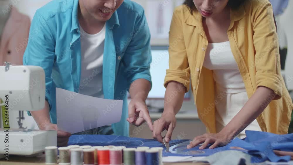 Asian Male And Female Designers With Sewing Machine Helping Each Other ...
