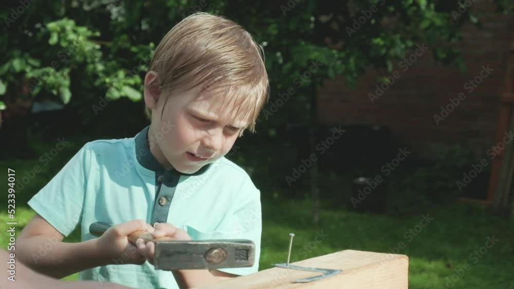 Father is in backyard on summer day with his little son working in ...