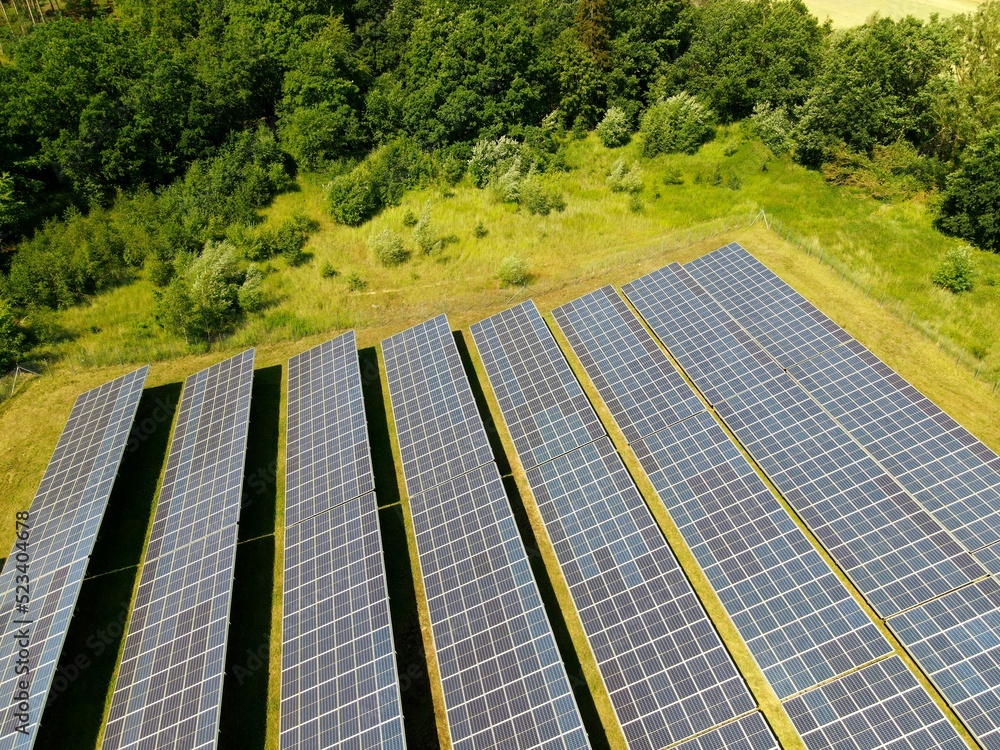 Photovoltaikanlage - Solarpark mit grüner Wiese und Wald im Hintergrund ...