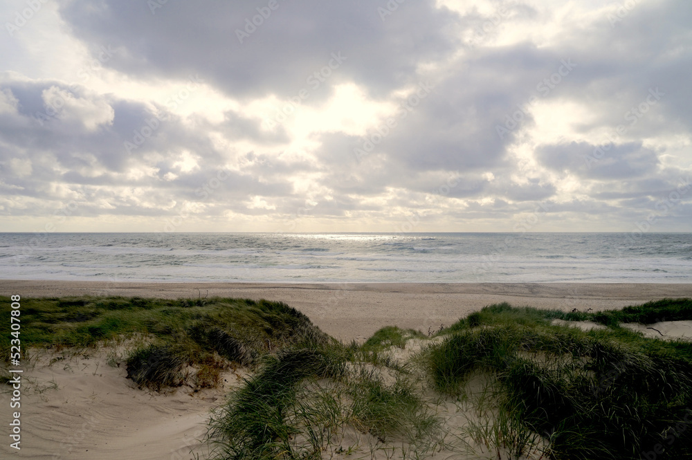 View from the dune of the beach and the raging waves of the North Sea ...