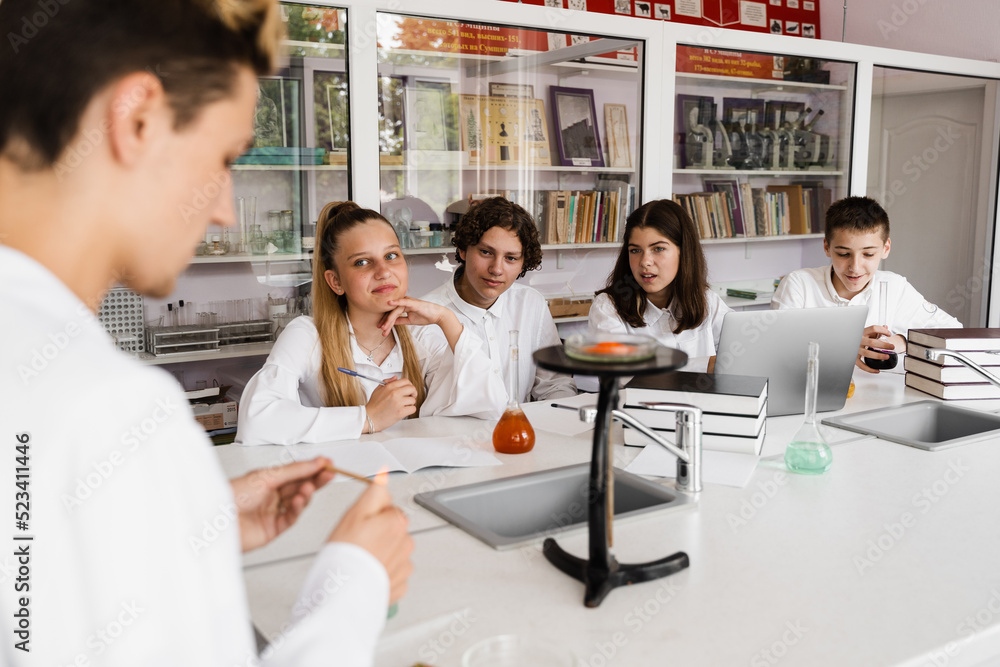 Experiment with fire. School chemistry teacher shows children ...
