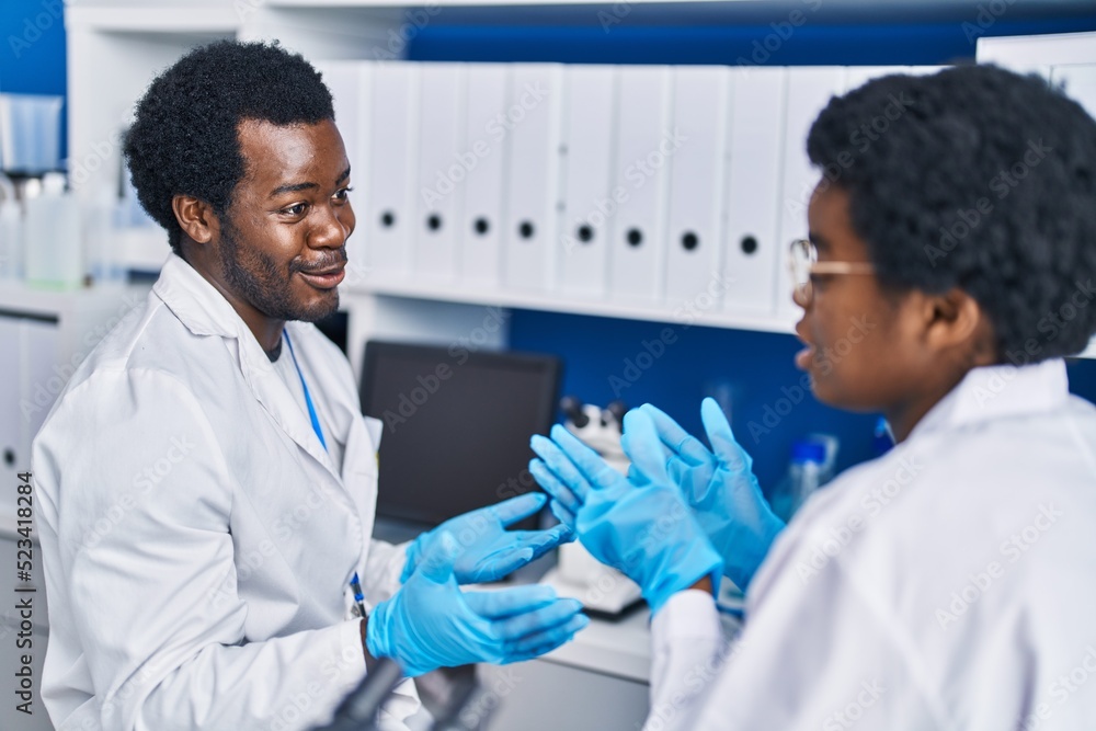 African american man and woman scientists working together speaking at ...