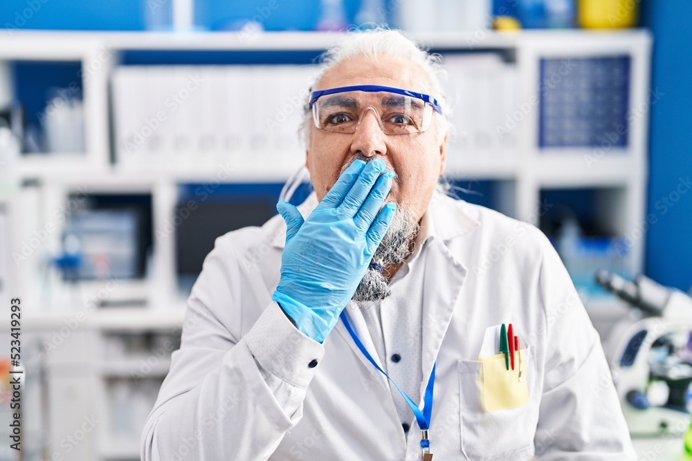 Middle age man with grey hair working at scientist laboratory covering ...