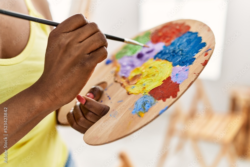 African american artist woman mixing color on palette at art studio ...