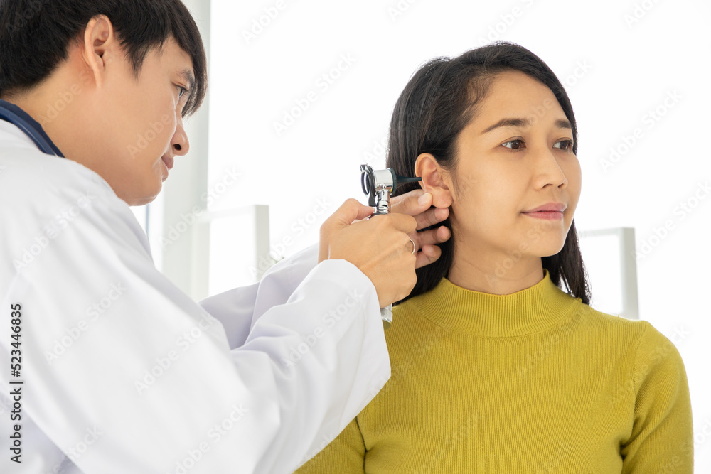 Audiologist examining young female patient ear using otoscope Stock ...