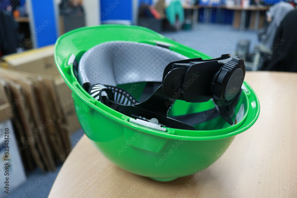 Green safety helmet complete with suspension and chin strap, this head ...