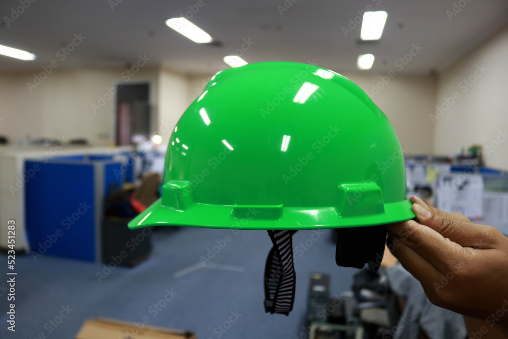 Green safety helmet complete with suspension and chin strap, this head ...