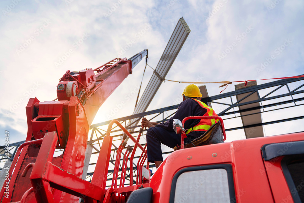 A Crane driver sit a top in a mobile crane cabin and working lifting ...