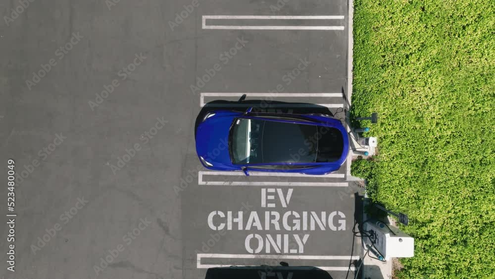 Vidéo Stock Aerial view of blue car charging in green business park. 4K ...