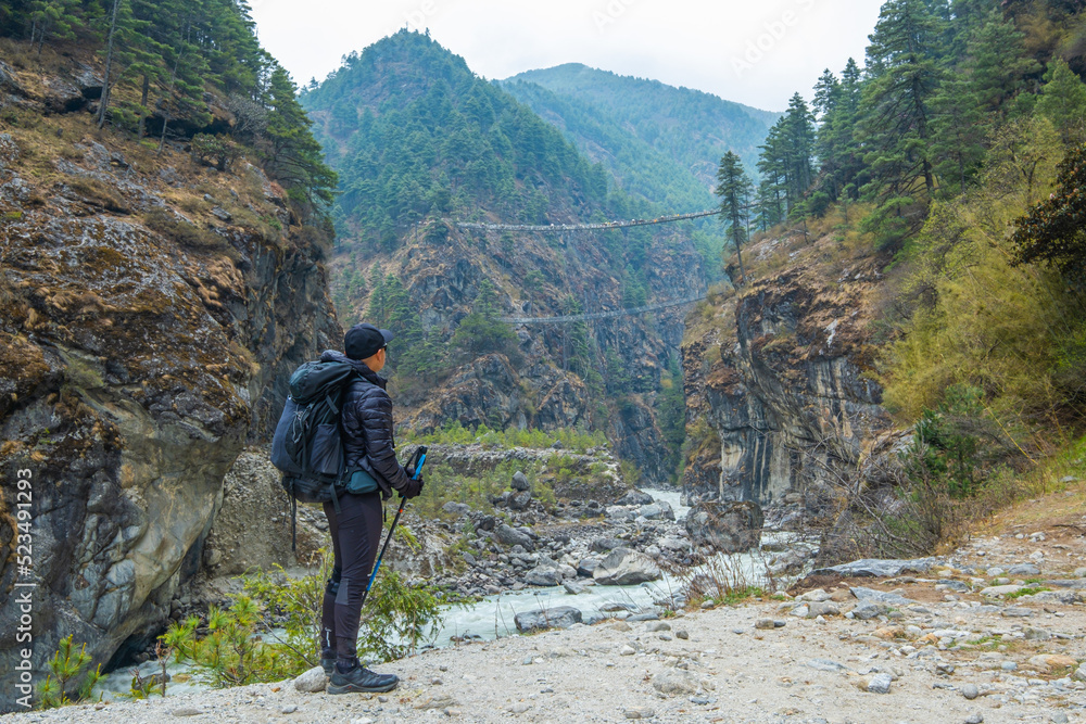 Tourist man looking to Tenzing-Hillary Suspension Bridge, the bridge ...