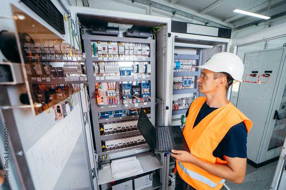 Adult electrician builder engineer testing and screwing equipment in ...