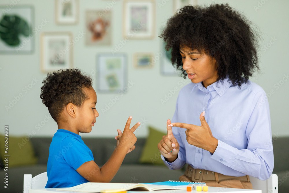 A smart boy counts on his fingers, studies with a private teacher in ...