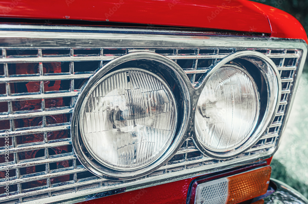 Headlights of a red car close-up. The front of an old red Lada car ...