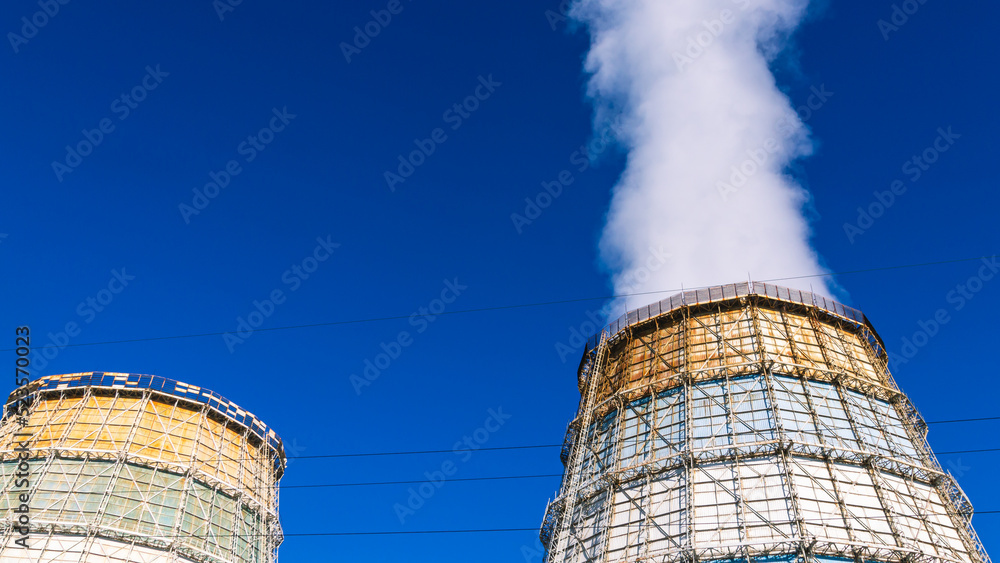 Large cooling towers of thermal power plants. White steam comes out of ...