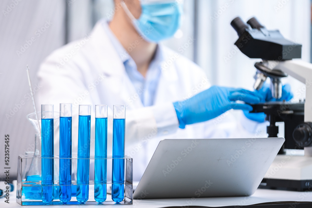 Scientist analyzing microscope slide at laboratory. Young woman ...