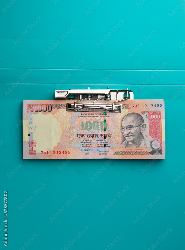 One thousand Indian rupee notes filed in a paper folder with clip. Old ...