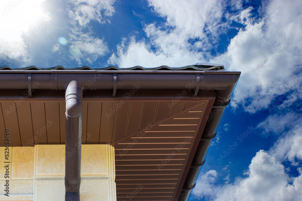 Roof gutter pipeline sysem on corner of house. Building rain gutter ...