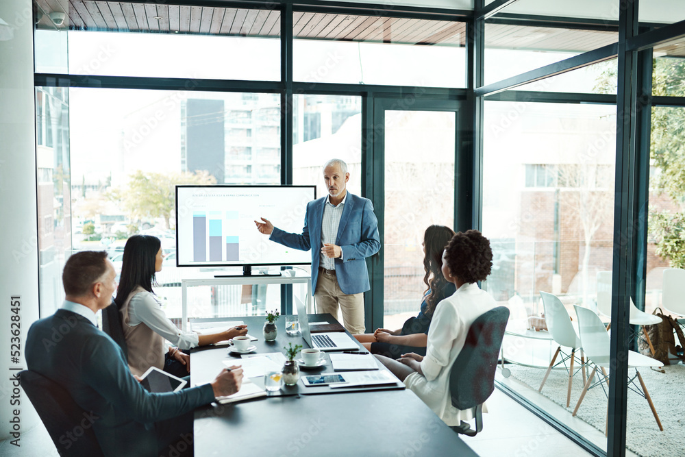 Businesspeople attending a presentation in the boardroom about growth ...