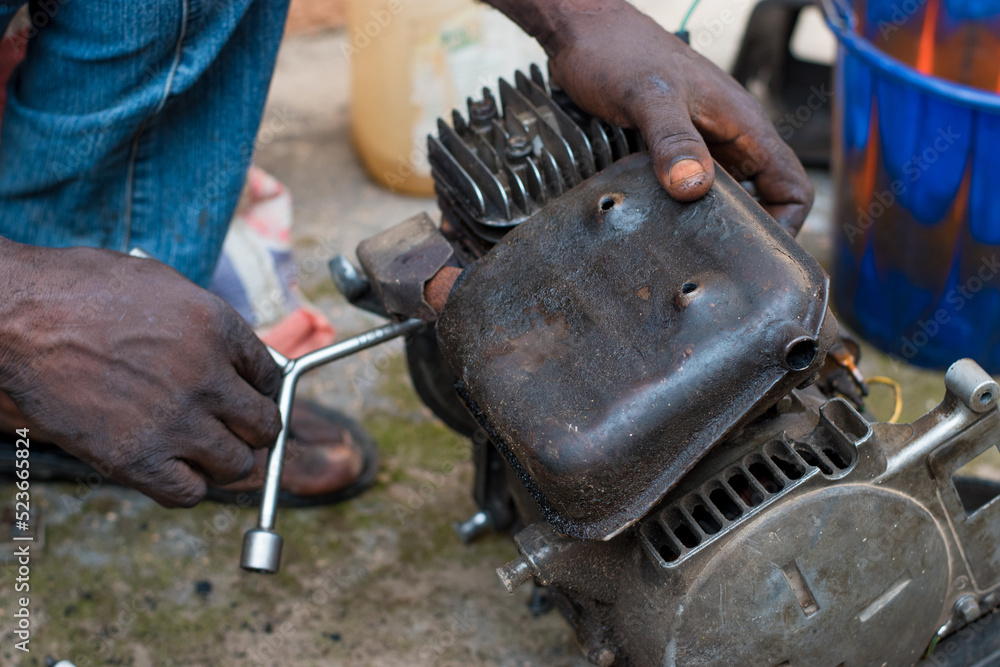 An Engineer working on a small electricity generator in an engineering ...