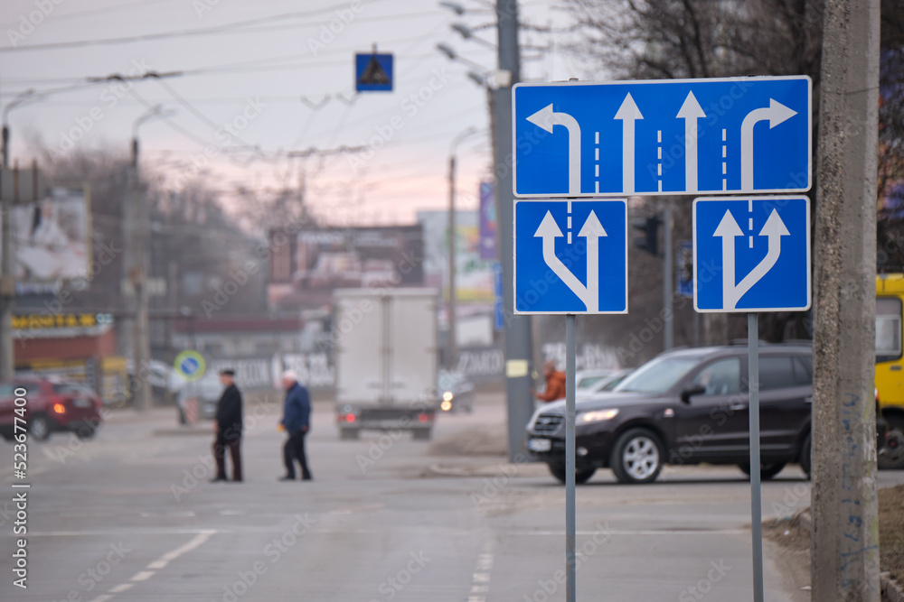 Traffic sign pointing multiple road lanes direction on city street ...