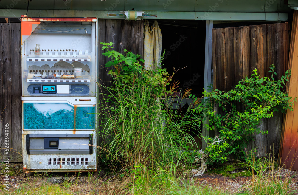 Foto de Old broken vending machine in front of abandoned shop with ...