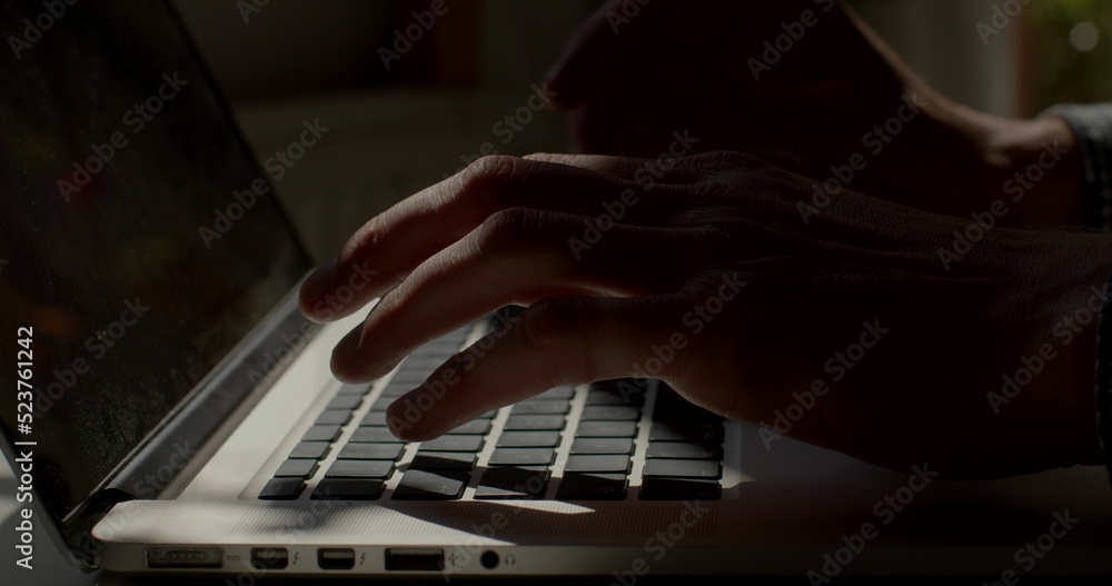 Light spot on a laptop keyboard. He presses buttons, prints text ...