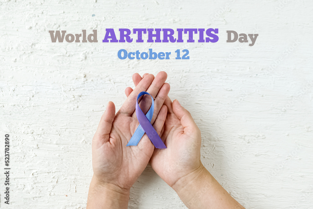 World Autoimmune Arthritis Day. The blue-purple ribbon in the hands of ...