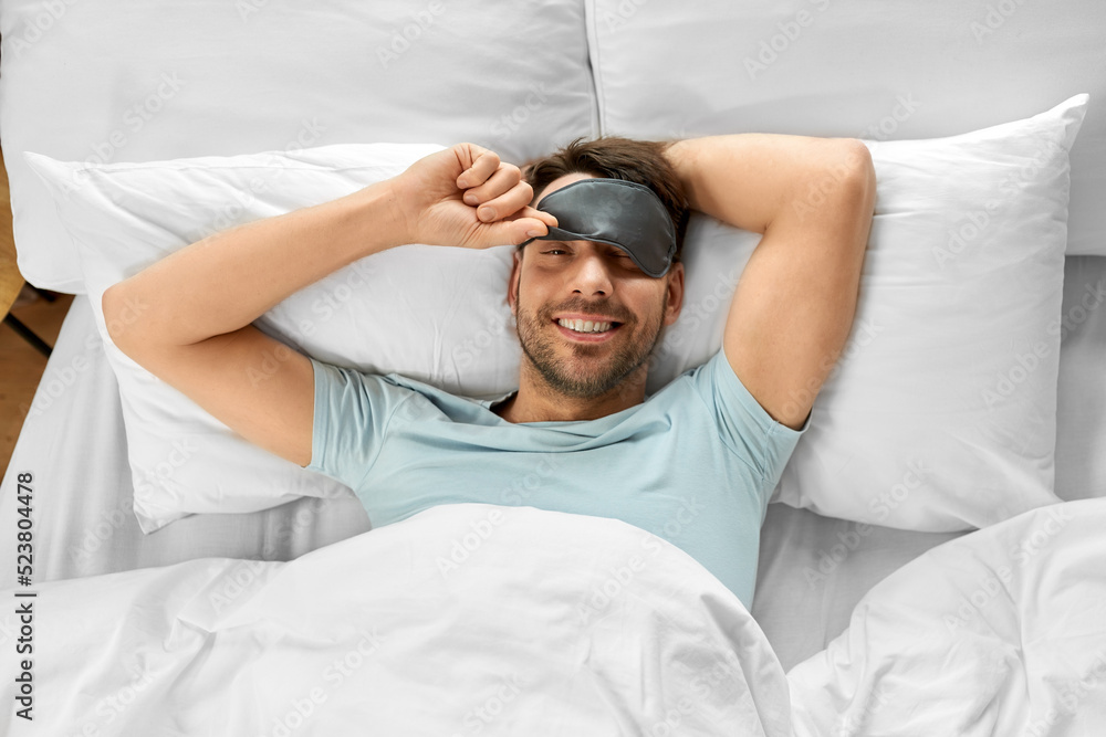people, bedtime and rest concept - happy smiling man in sleeping eye ...
